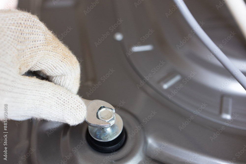 tightening the nuts. hand using an open end wrench to tighten a nut ...