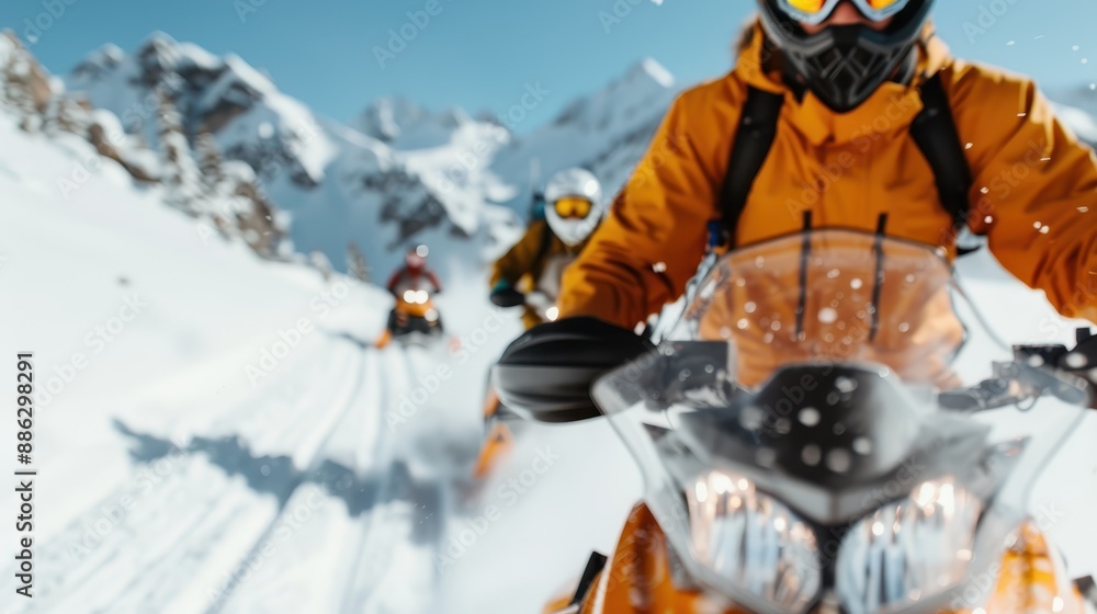Three snowmobile riders traverse a stunning snowy mountain landscape ...