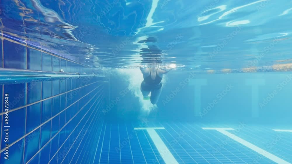 Under water view of professional female swimmer. Woman athlete swimmer training at swimming pool ...