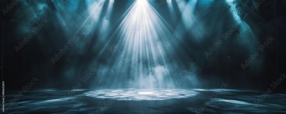 A dance stage with a single bright white spotlight in the center. The ...