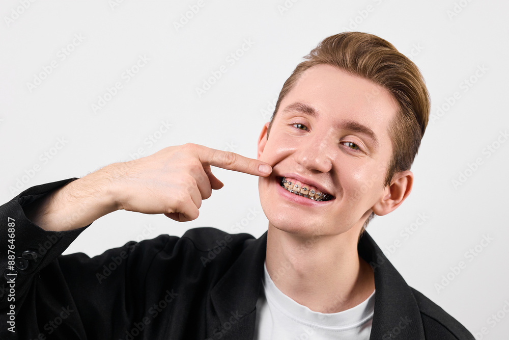 A man is playfully sticking his index finger in his mouth, creating a ...