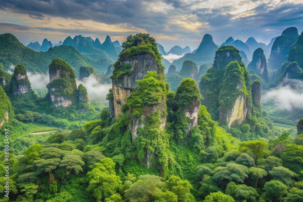 Lush green tropical forest surrounds towering Karst hills, their rugged ...