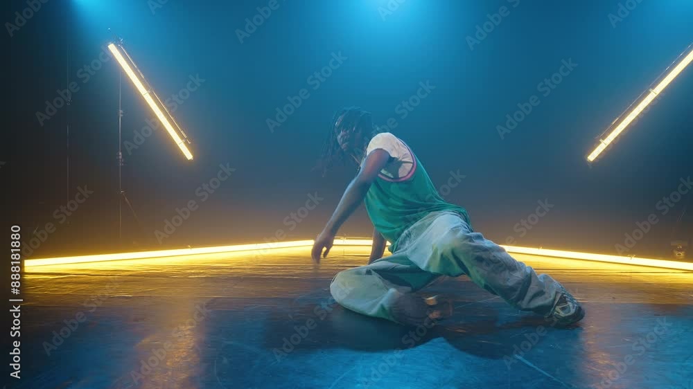 Dancers performing a modern hip hop dance in a black studio with ...