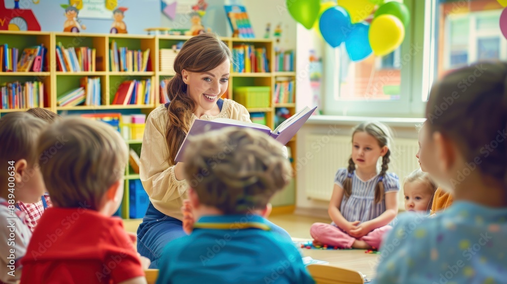 Cheerful teacher reading to class of young children in kindergarten ...