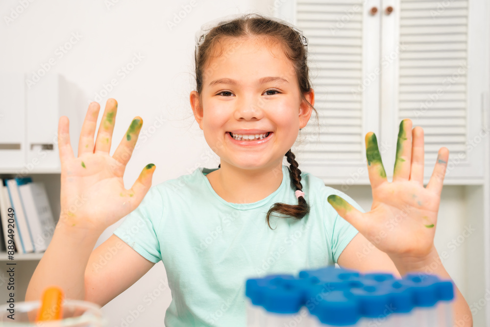 Cheerful young student girl with stained hands smiles in a laboratory ...