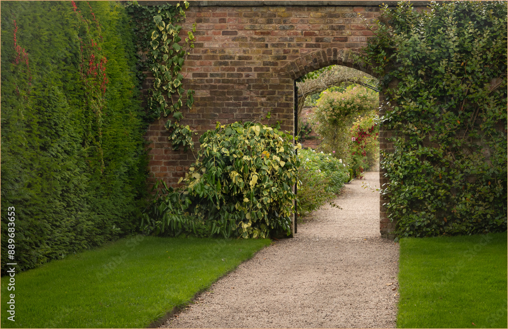 Pathway to an open door leading into a walled garden Stock Photo ...
