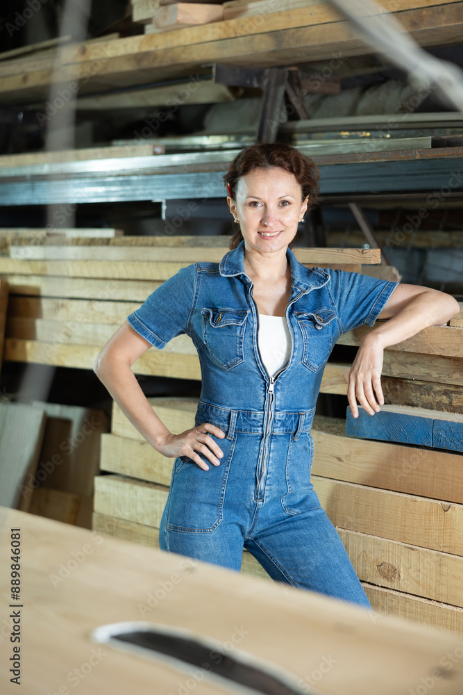 Woman employee of carpentry workshop took time out from work, stands ...