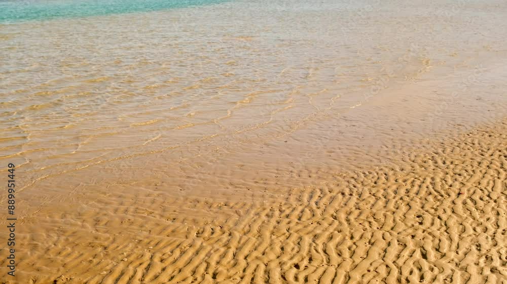 Top view of abstract sand patterns as seawater rolls in over intertidal ...