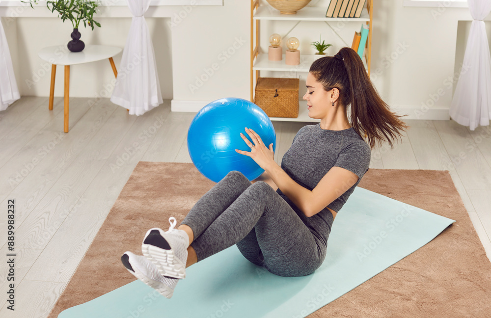Beautiful young girl doing exercises lying on yoga mat with fitness ...