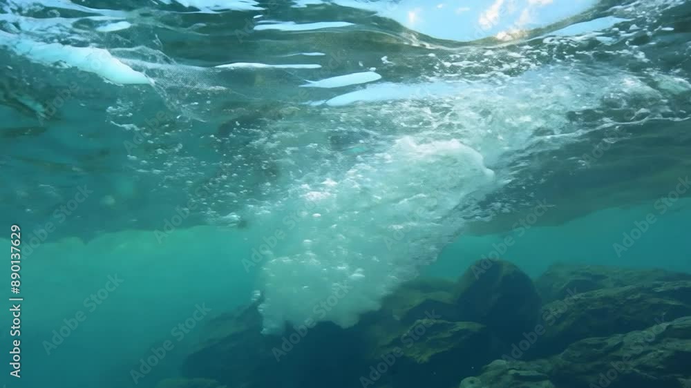 A waterfall from beneath the water surface showing the bubbles and ...