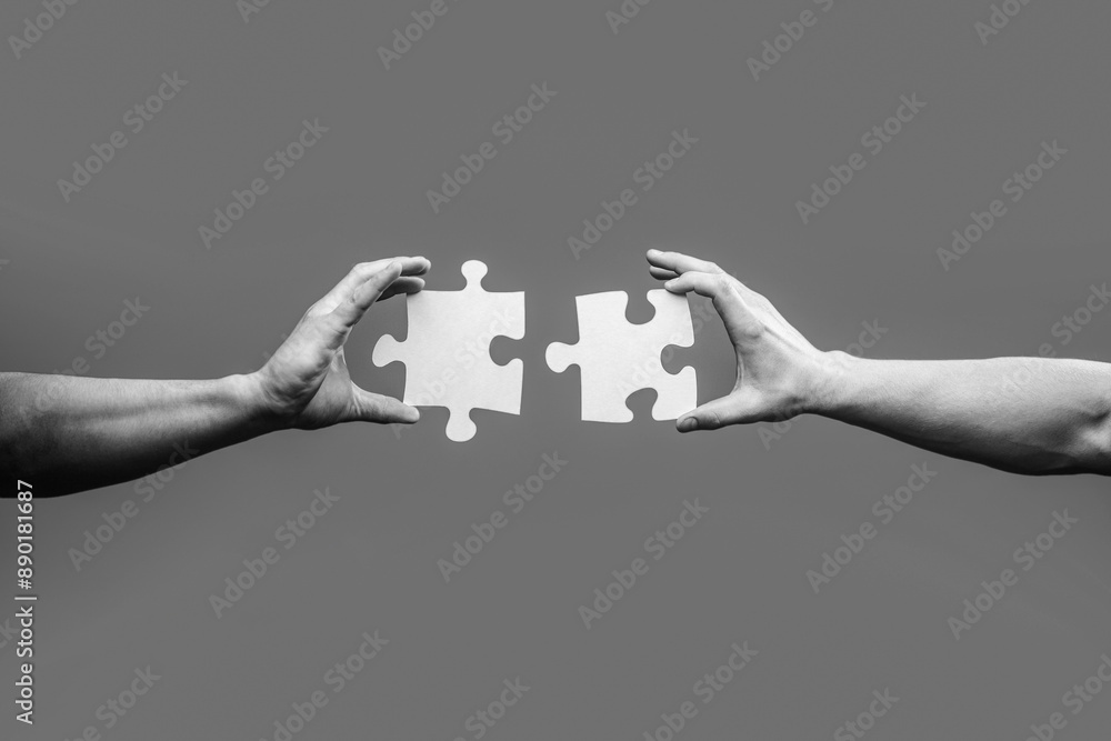 Men holding and putting a piece of jigsaw puzzle together. Two hands ...
