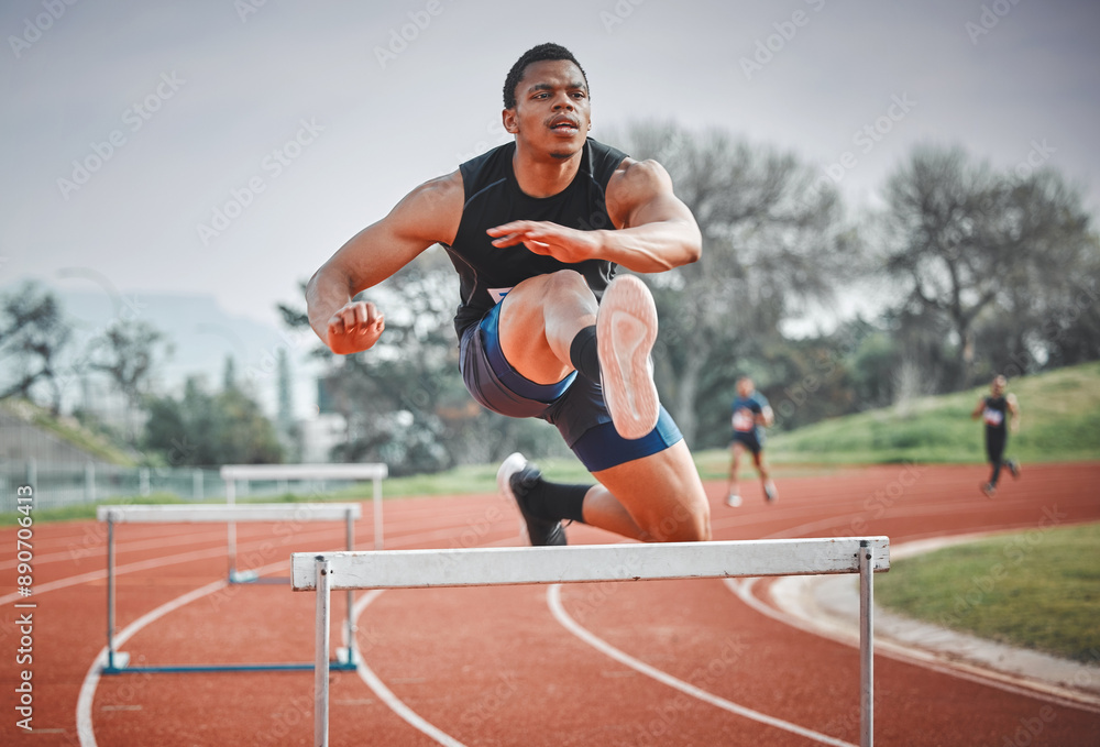 Hurdles, fitness and man running on track at stadium training for race ...
