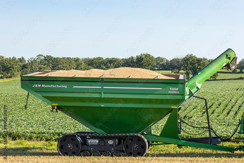 J & M Manufacturing 1050 GrainStorm grain cart on tracks filled with ...