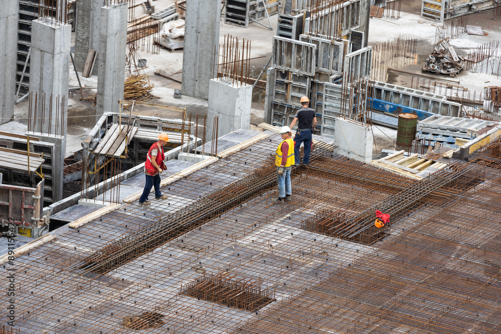 Aerial view of busy industrial under construction site workers working ...