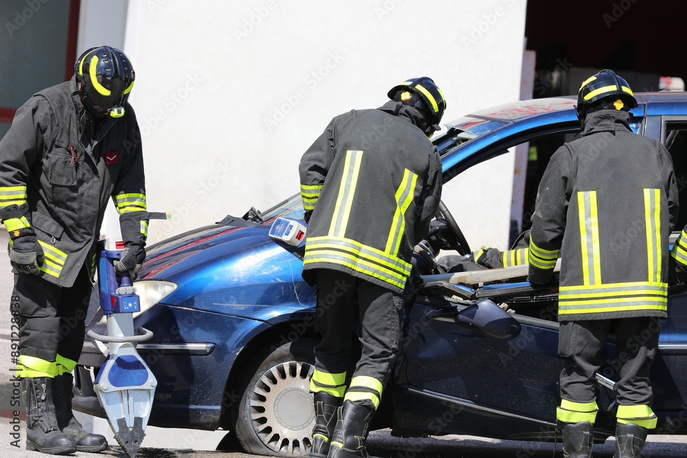 Firefighters using powerful shears and hydraulic spreaders pry open the ...