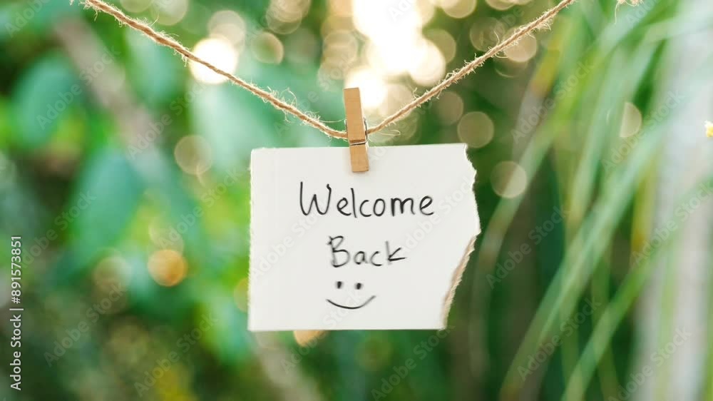 Note paper with Welcome Back text hanging on a rope and swinging in the ...