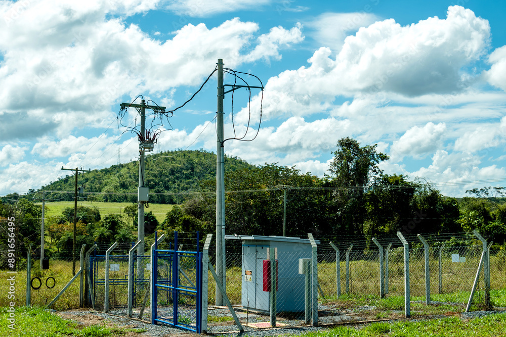 work of a medium voltage transformer with poles, wires, enclosure and ...