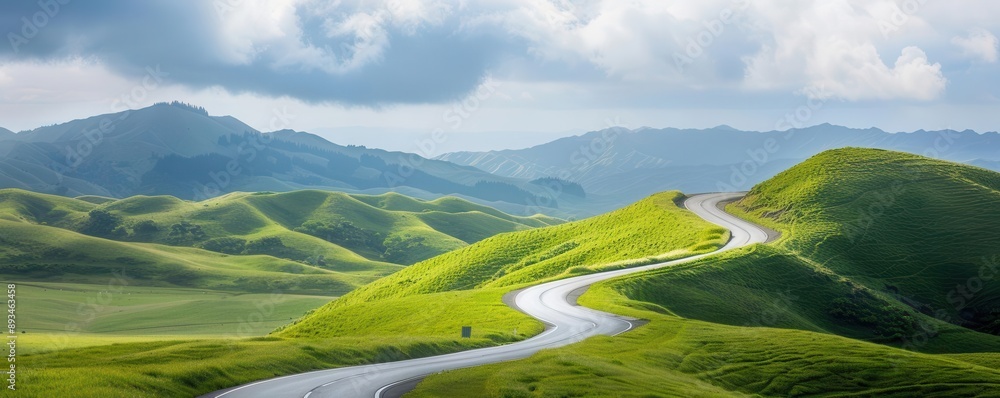 Highway through rolling hills under a dramatic sky, representing the ...