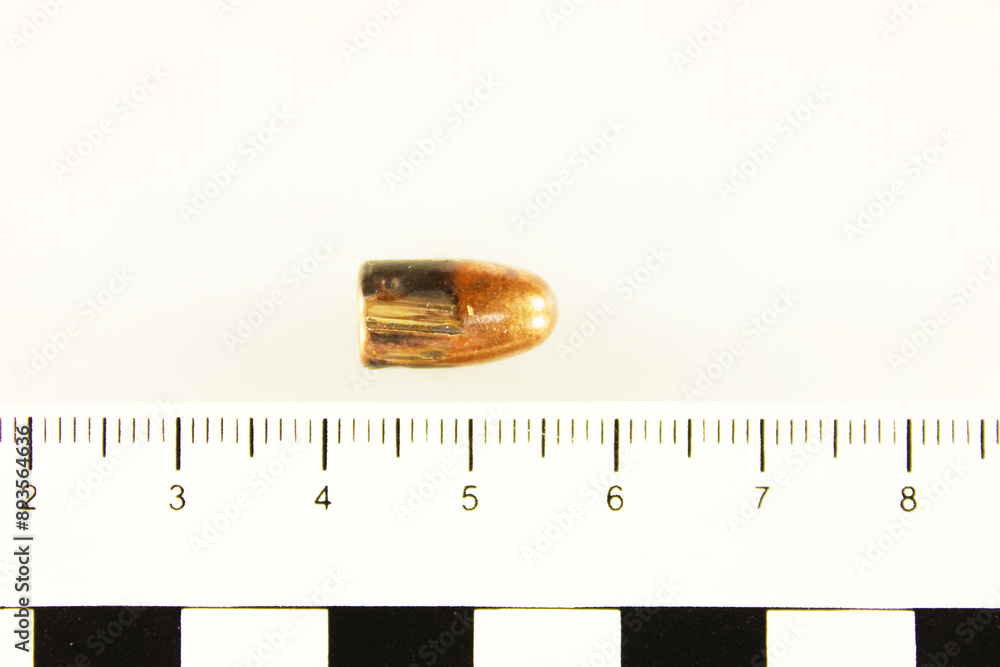 A fired .32 caliber pistol cartridge bullet with traces of rifling, on ...