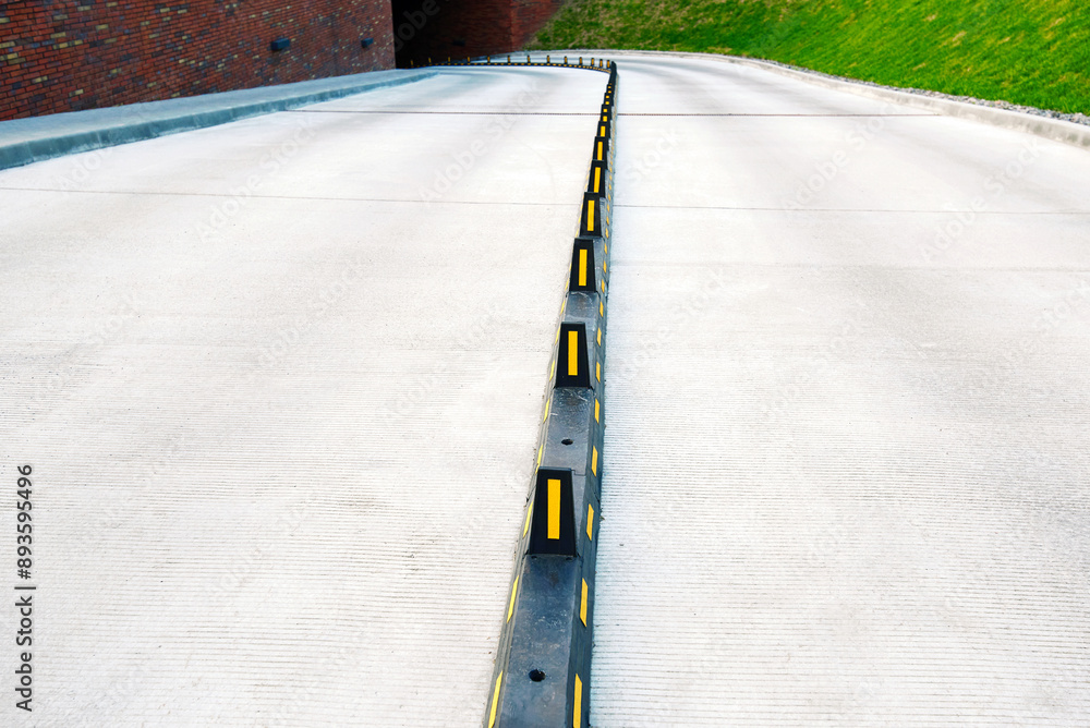 Underground garage entrance. Rubber lane dividers on concrete road ...