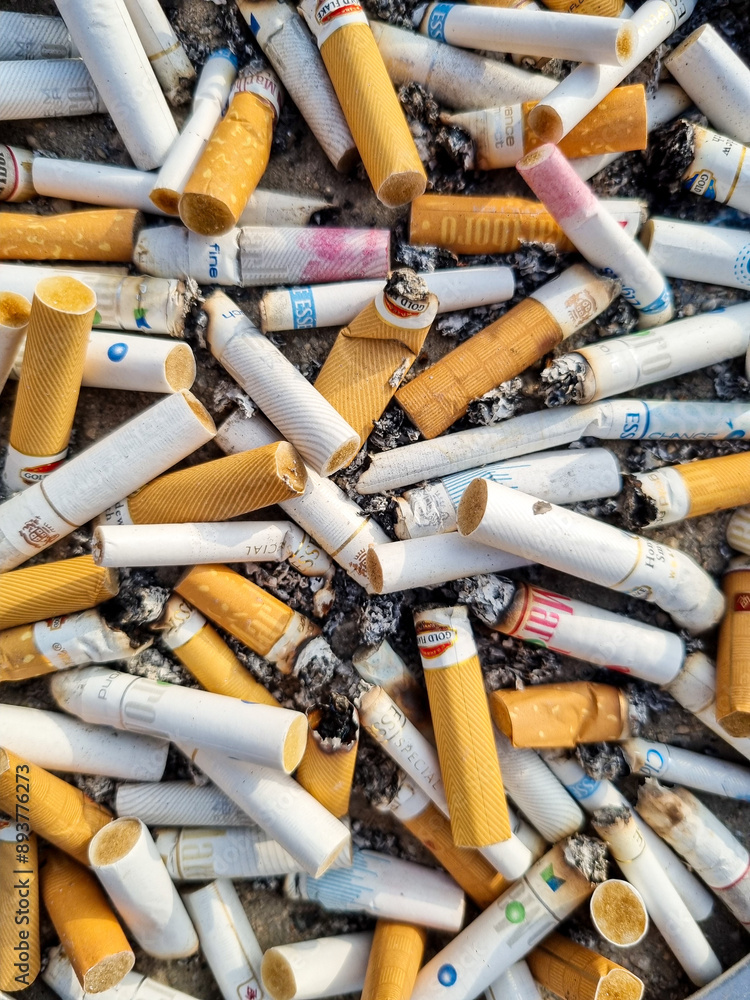 Foto de Collection of Ash and stubbed out cigarette butts buds in ...