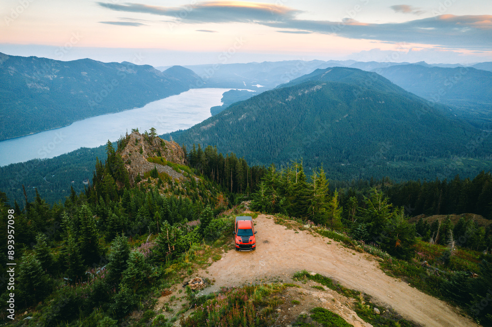 Aerial shot of shot of a pickup truck standing on the cliff with a backdrop of North Cascades ...