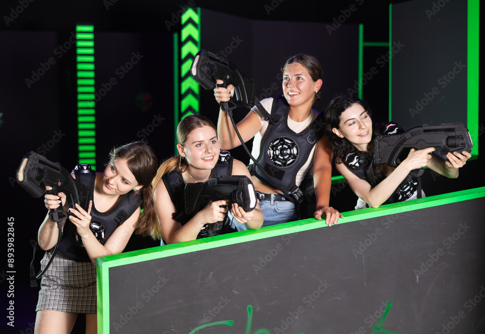 In laser tag studio, girls play with toy machines, shine laser beam ...