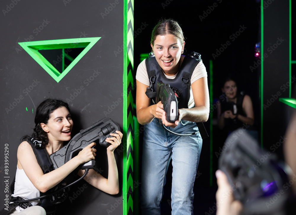 In laser tag studio, girls play with toy machines, shine laser beam ...