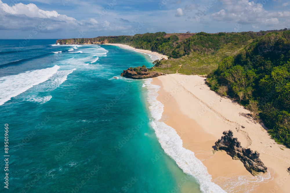 Expanse of Mbawana Beach with the surf rolling into the rugged ...