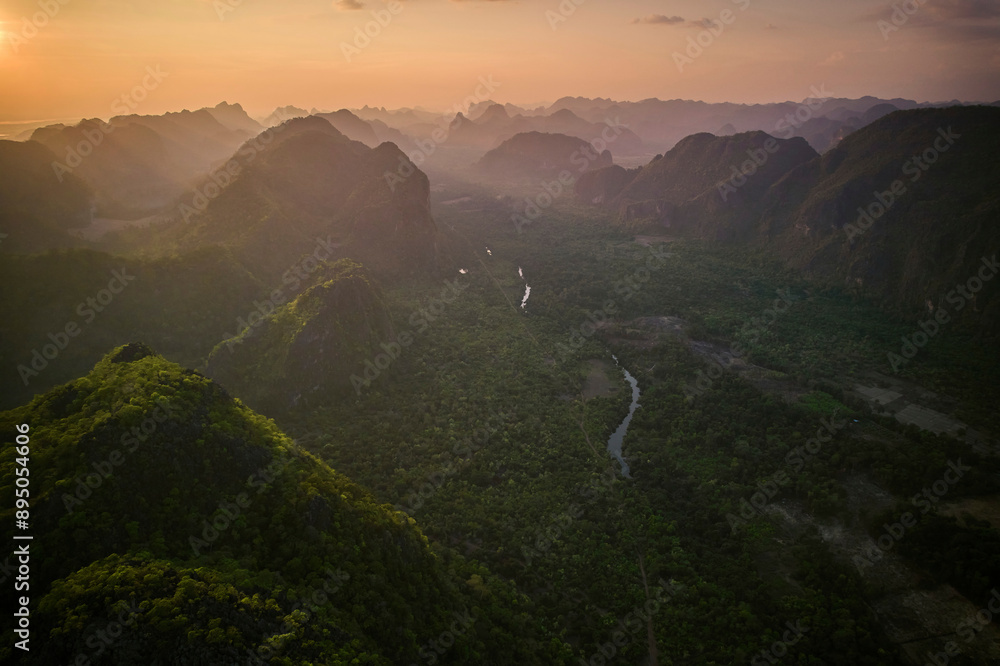 Sunset light over the rugged landscape with limestone karst formations ...