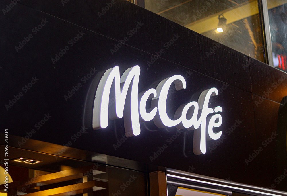 McCafe logo banner outdoors glowing in dark. Fast-food chain sign Stock Photo | Adobe Stock