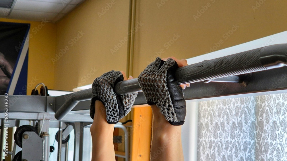 Closeup of Hands Wearing Workout Gloves Gripping a Pull-Up Bar in a Gym ...