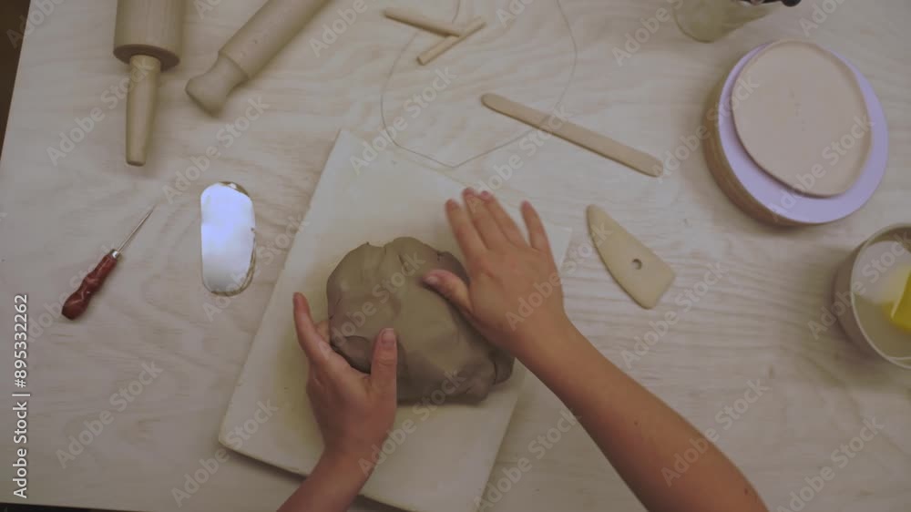 Wedging the clay before starting making a pottery project to create ...