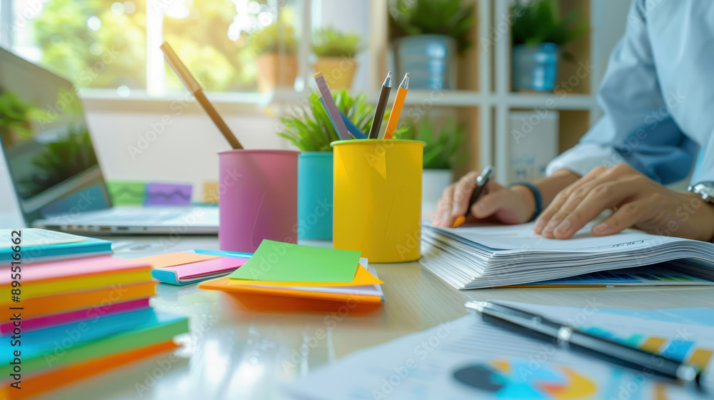 Bright and colorful workspace with stationery items, focusing on hands ...
