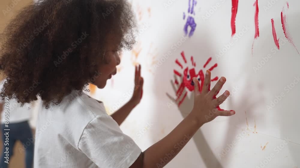 Diverse student touch hands with color at stained wall in art lesson ...