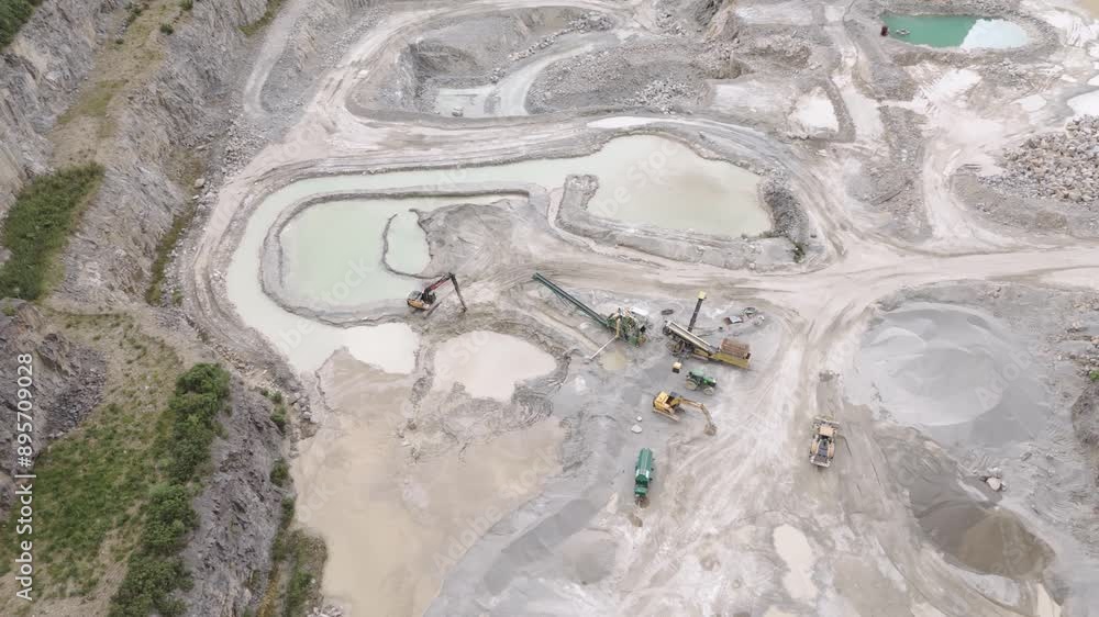 Orbital drone shot of an aggregate quarry pit, highlighting the depth ...