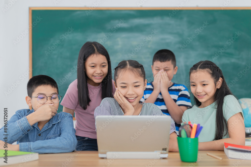 Asian kids gather around laptop, expressions range from laughter to ...
