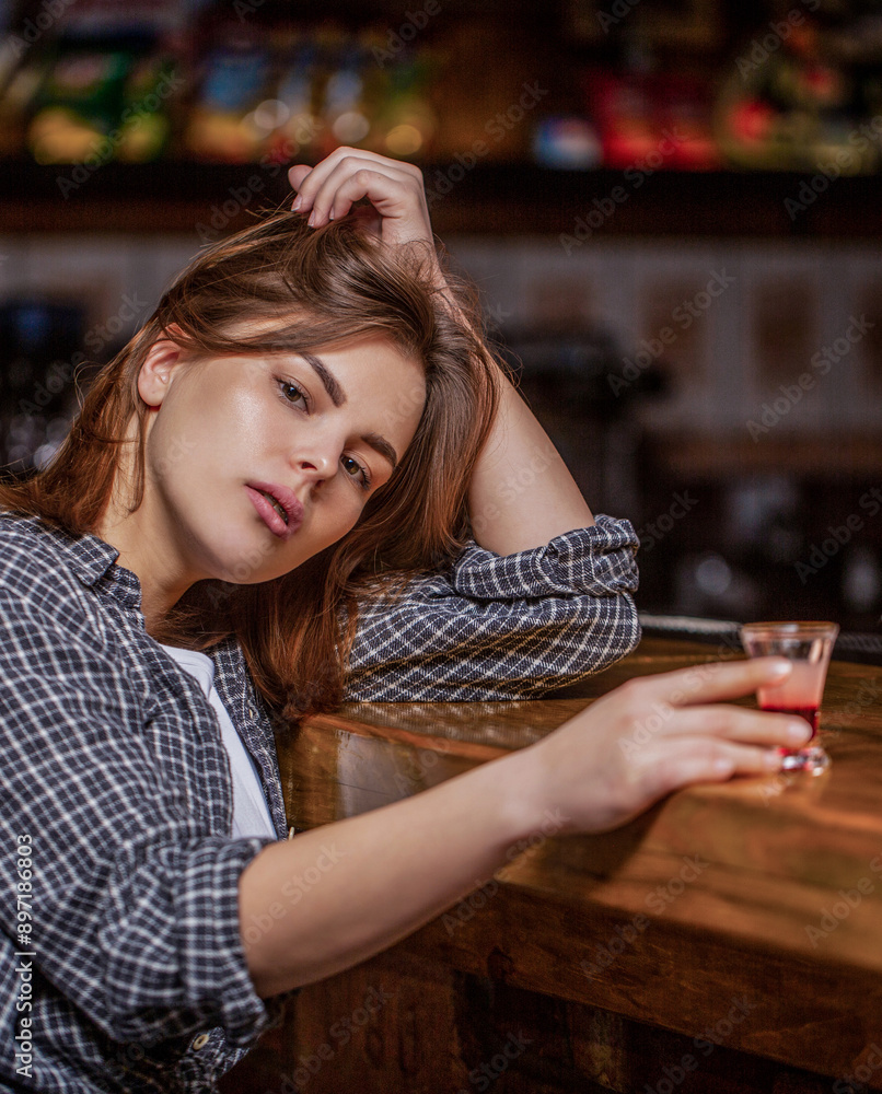 Portrait of drunk woman with glass of alcohol sitting t table at pub ...