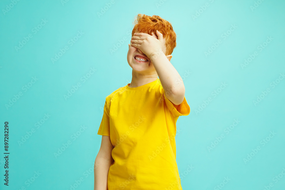 Puzzled worried red haired boy covers eyes with hand, frowns face ...