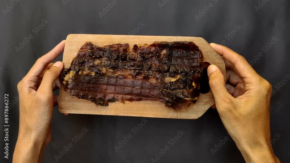 A hand holds and displays "Dendeng Rusa" from Merauke, Papua, Indonesia ...