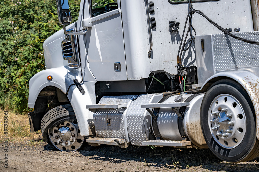 Broken down white big rig semi truck with a twisted wheel and a ...