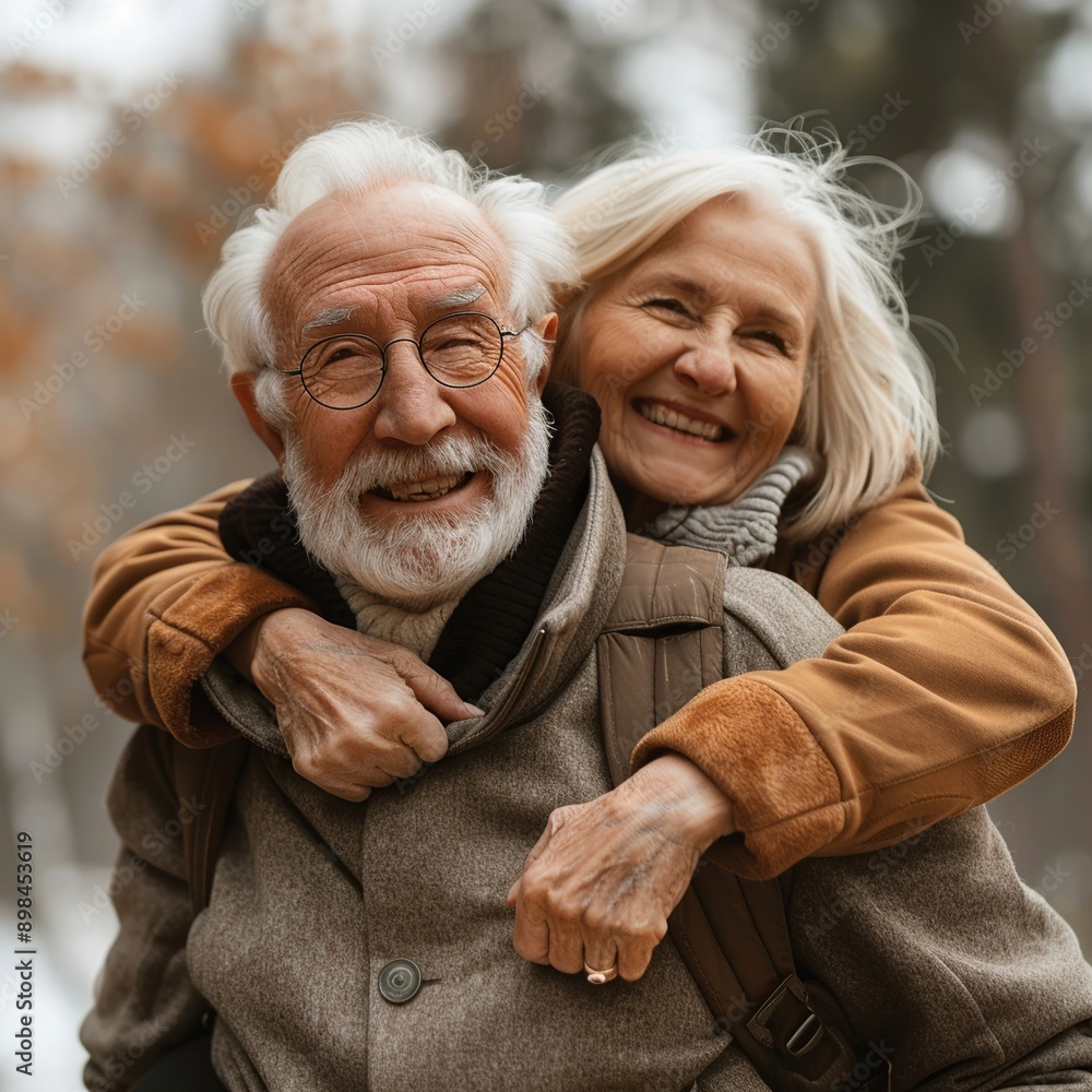 An elderly husband gives his wife a piggyback ride during outdoor ...