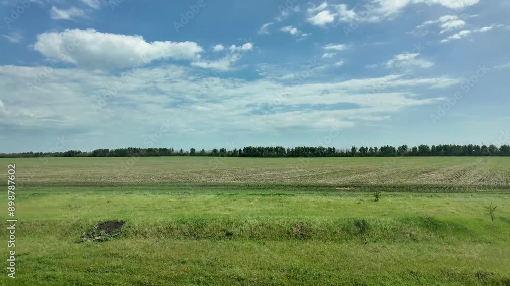 View from the window of endless fields, blue sky with clouds, train ...