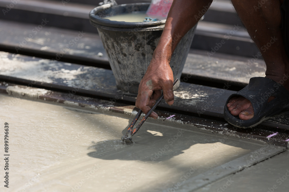 Construction worker using pincer plier cutting steel binding wire wet ...