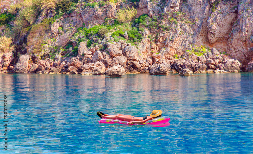Girl in bikini lying on air bed - Cliffs (Falez) in the sea Rock ...