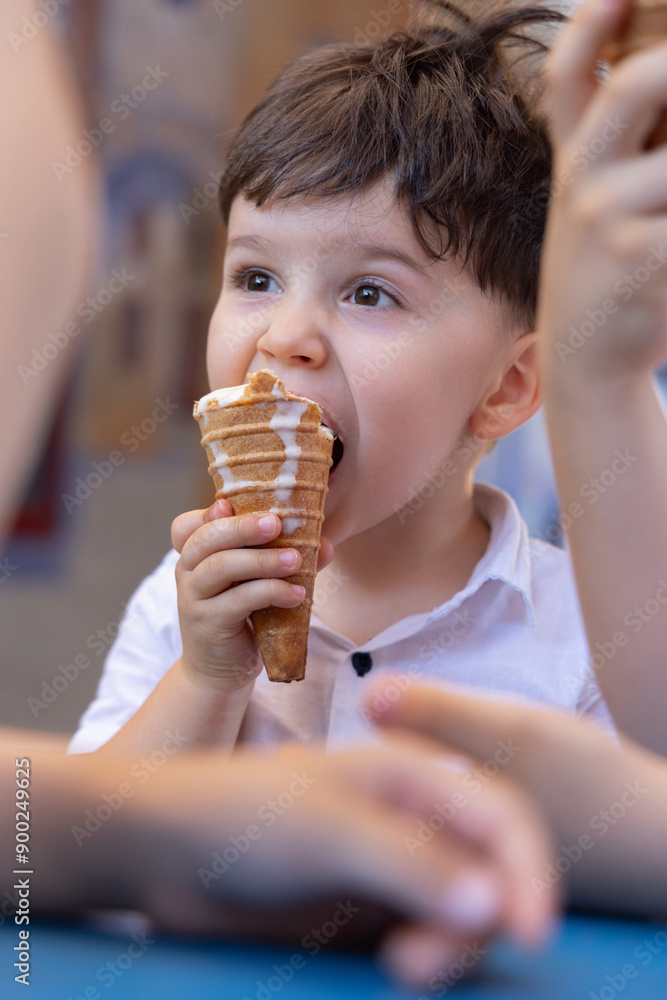 cute boy or girl eating ice cream outside. lustful kids eating from ...