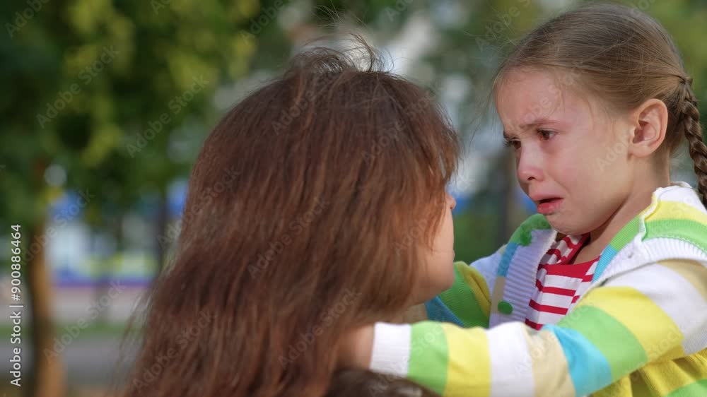little child cries, tears child face, mother calms capricious kid girl ...