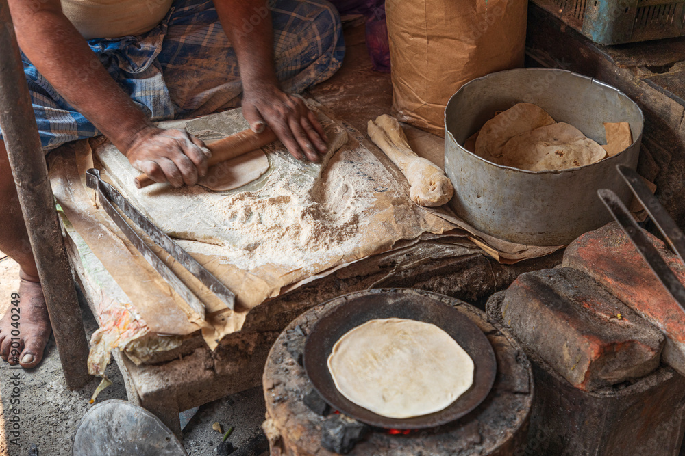 India, West Bengal, Kolkata, Bow Bazaar. Man rolling dough to make naan ...