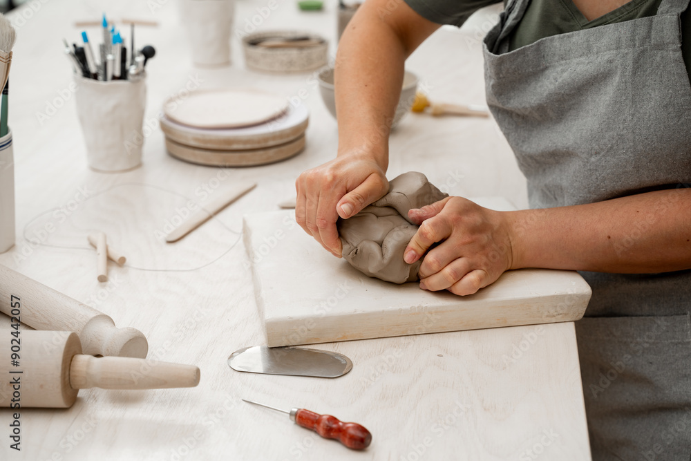 Wedging the clay before starting making a pottery project to create ...
