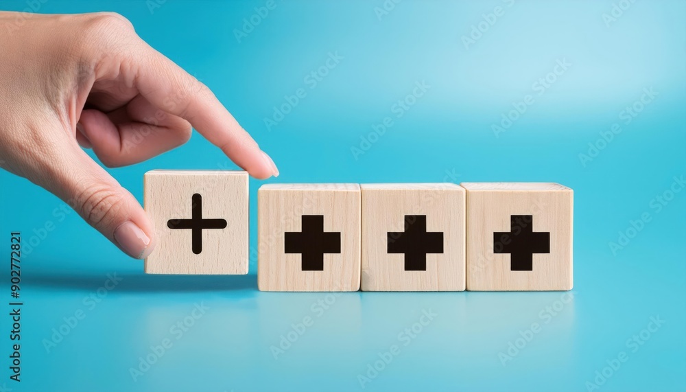 Value add concept. Hand place wooden cube with plus sign on light blue ...